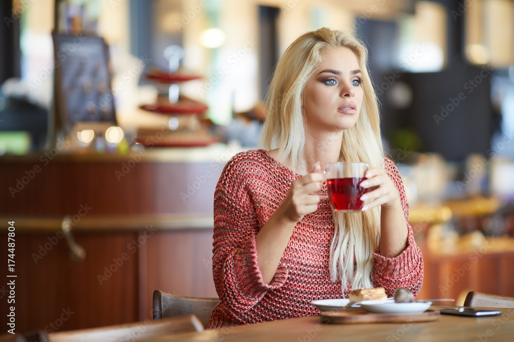 Young fashion woman drinks tea a cafe. caucasian woman sitting in act ...