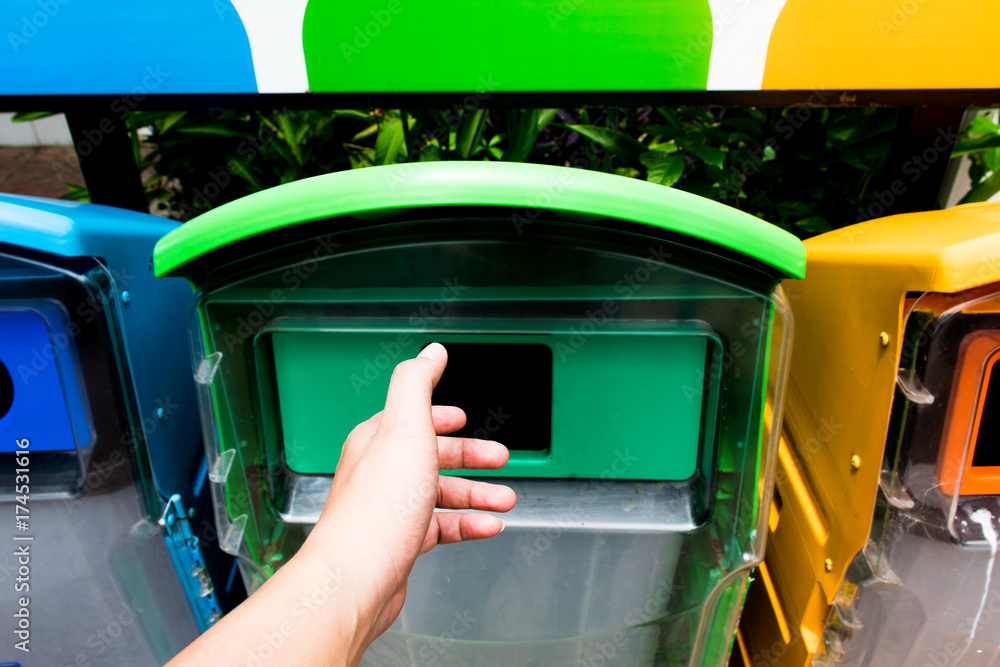 Hand throwing waste into recycling bin, concept of environmental ...