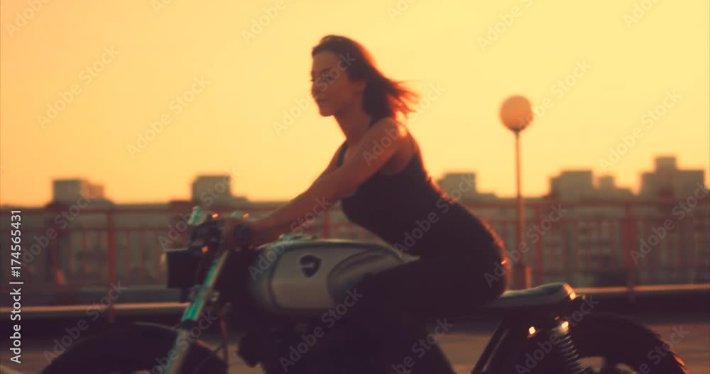 Beautiful Caucasian female biker riding her custom built cafe racer ...