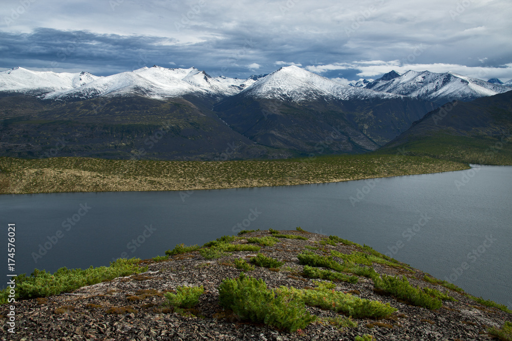 Mountain lake and mountain range with snowy peaks. Ridge Chersky ...