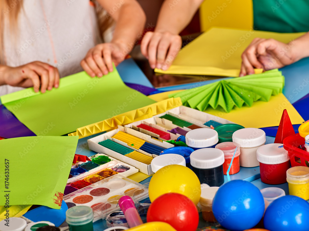 School children with scissors in kids hands cutting paper with teacher ...