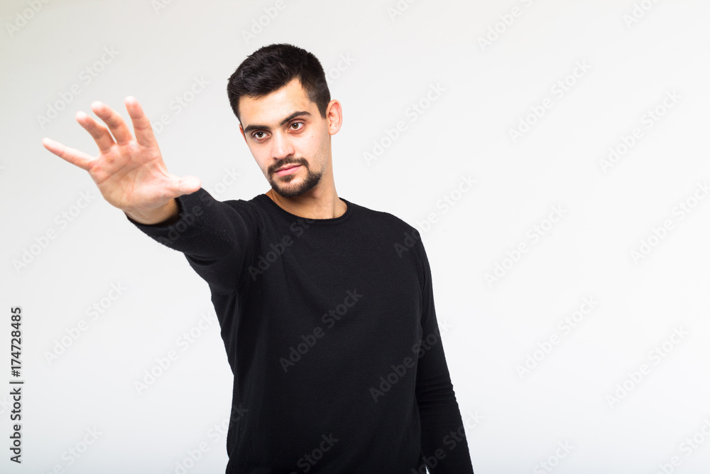 A young man with a force pulls his hand forward with his open palm ...