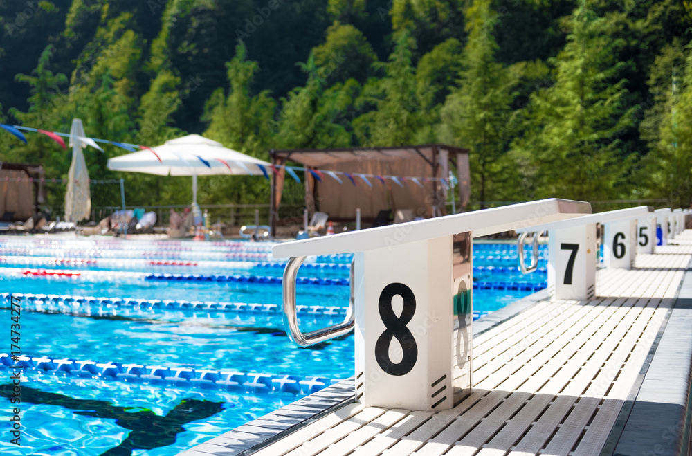 Starting places in an Empty Olympic swimming pool with clear blue water ...