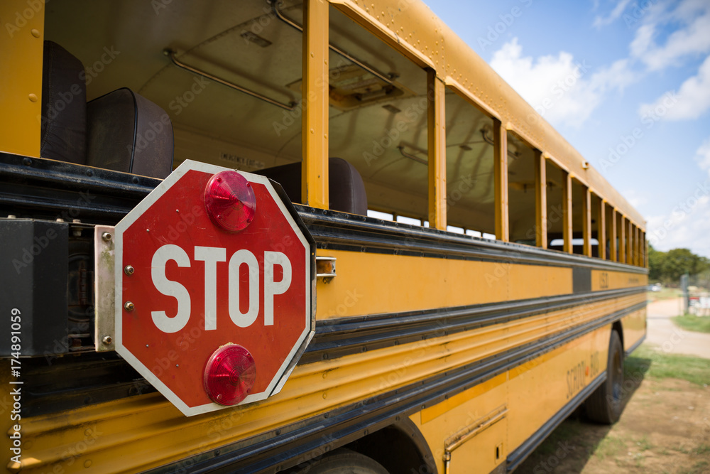 A red stop sign with lights on the side of an old yellow school bus ...