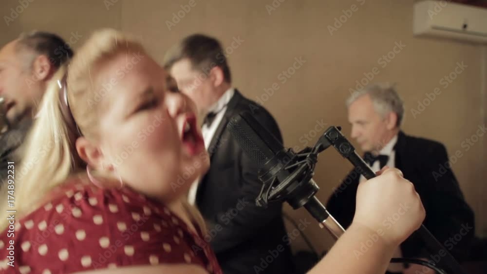 Vidéo Stock Three musicians and a cheerful fat girl sing and dance in ...
