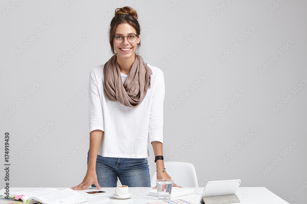 Picture of successful female model wears formal clothes, stands at work ...
