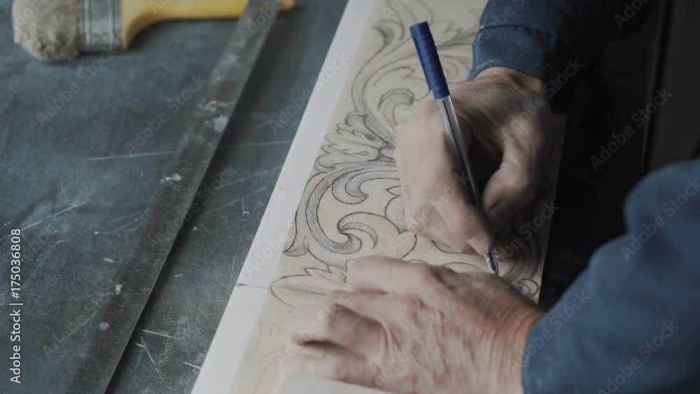 Engraver artist lines the lines on the fluted paper using a pen and a ...