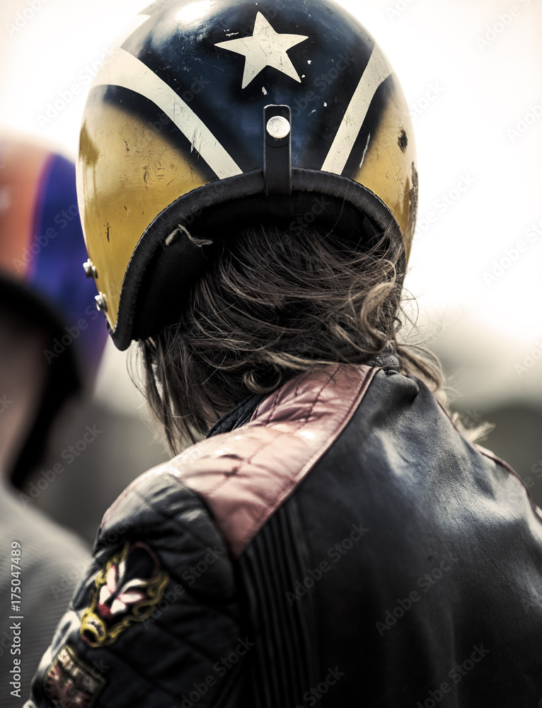 Rear view of man wearing yellow and blue crash helmet and black leather ...
