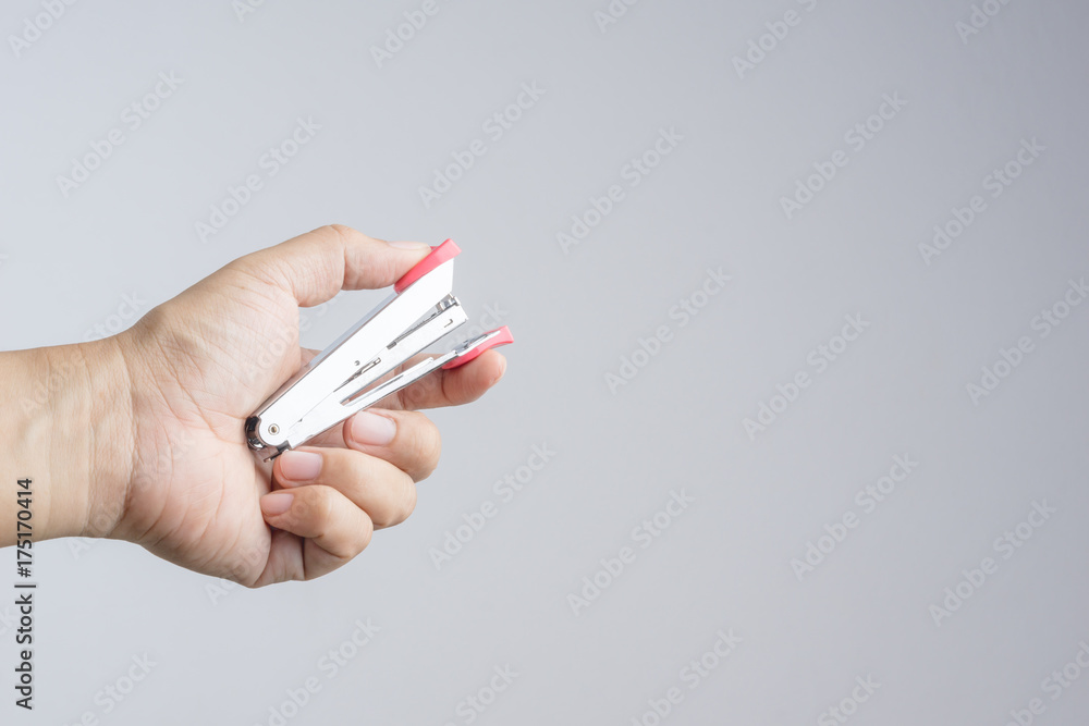 Hand holding stapler, an office supplies for stapling pages of paper or ...