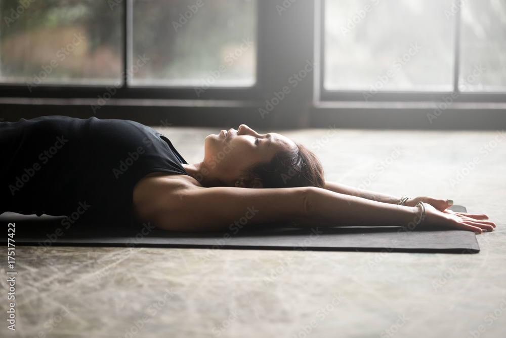 Young attractive woman practicing yoga at home. Doing stretching ...
