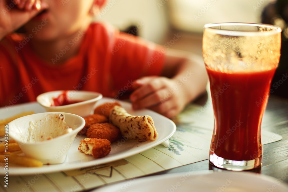 boy eating fast food in a cafe. the child eating french fries with ...