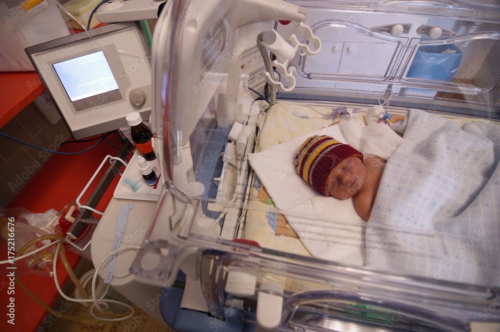 Newborn child baby sleeping in incubator. A neonatal intensive care ...