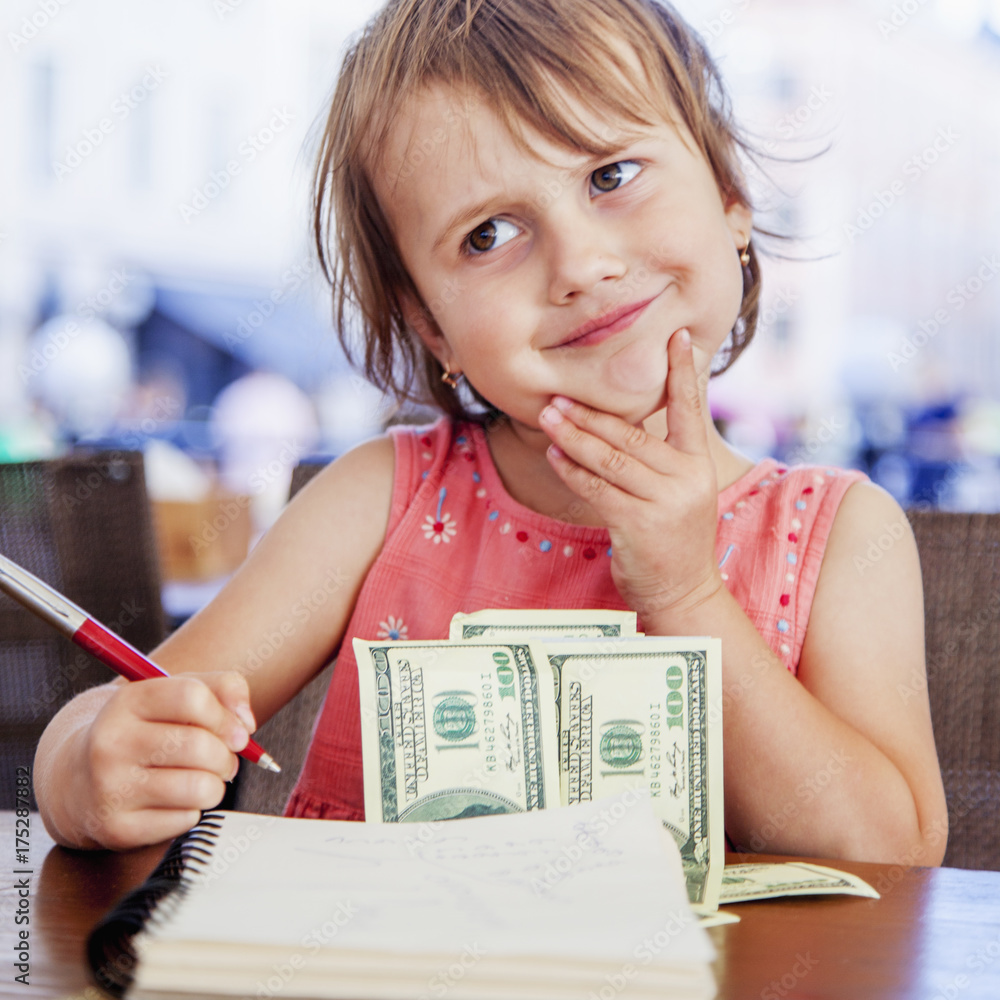 Little business child girl with US dollar banknotes plans the family ...