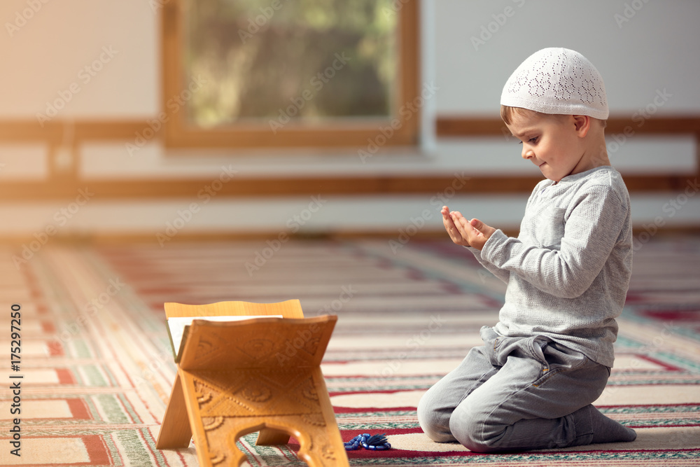 The Muslim child prays in the mosque, the little boy prays to God ...