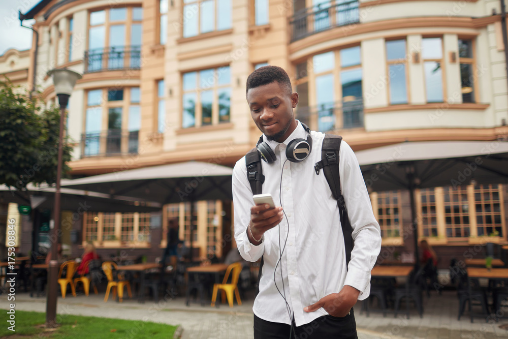 African man walking and looking at electronic map in smart phone. Stock ...