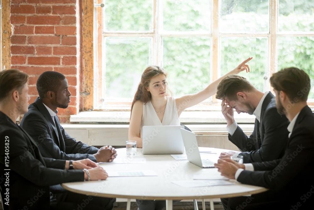 Strict female boss telling upset male employee to leave meeting room ...