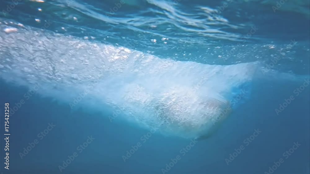 Running into swimming pool from water slide in slow motion. Underwater ...