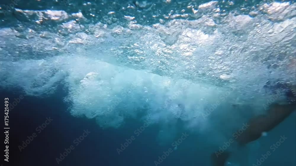Running into swimming pool from water slide in slow motion. Underwater ...