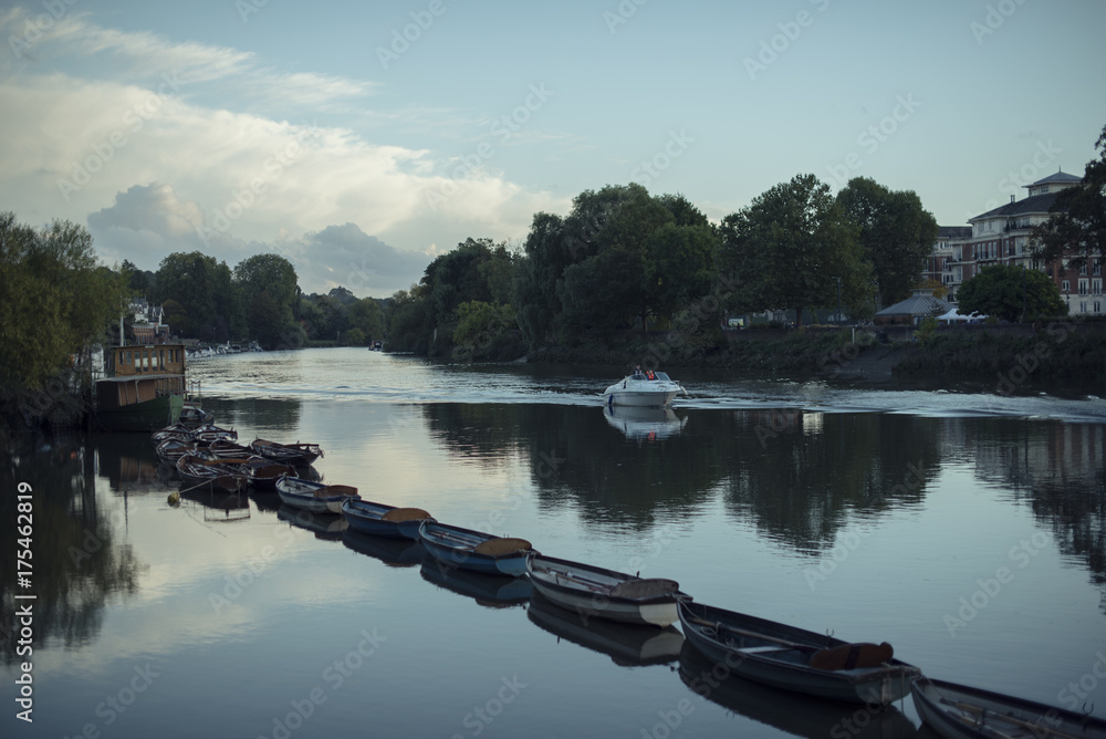 Paisaje de río sobre el que pasa una pequeña embarcación. Escena ...