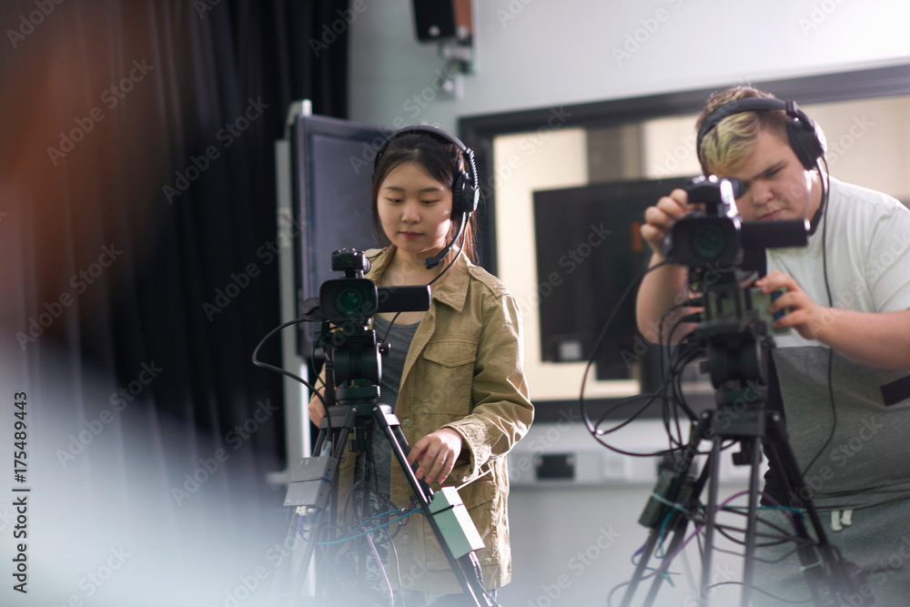 Over shoulder view of college students filming in TV studio Stock Photo ...