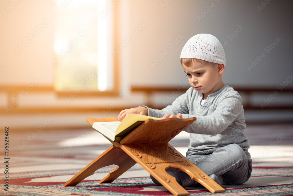 The Muslim child prays in the mosque, the little boy prays to God ...