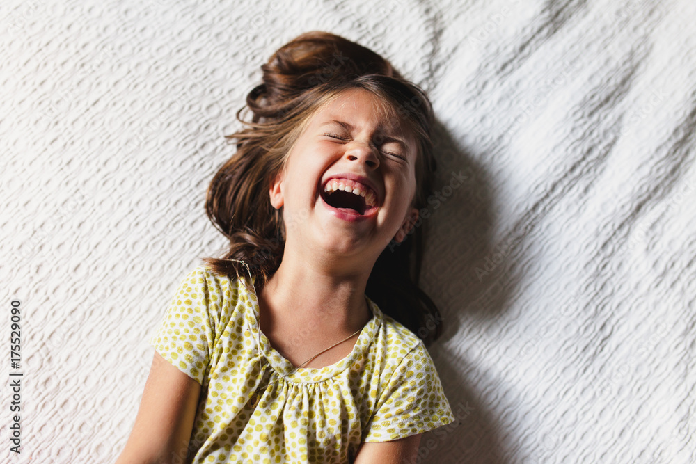 Young girl laying down laughing Stock Photo | Adobe Stock