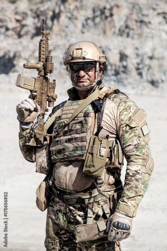 Half length location shot of big muscular soldier in field uniforms ...