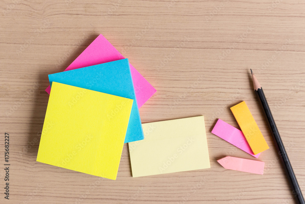 Collection of sticky note and black pencil on wood office desk on top ...