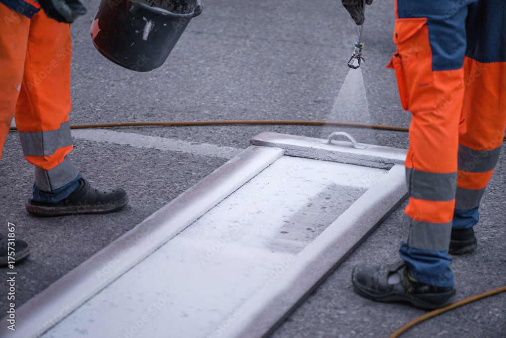 Traffic line painting. Workers are painting white street lines on ...