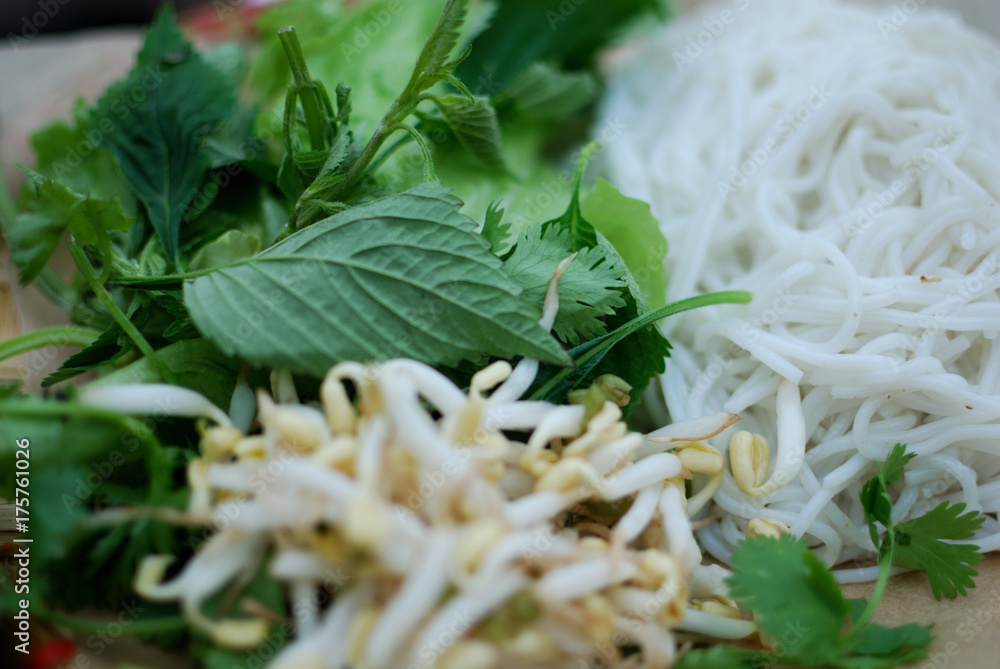 Pile of rice vermicelli with vietnamese herbs: perilla, cilantro, mint ...