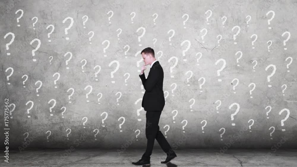 Confused Caucasian businessman walking back and forth in front of ...