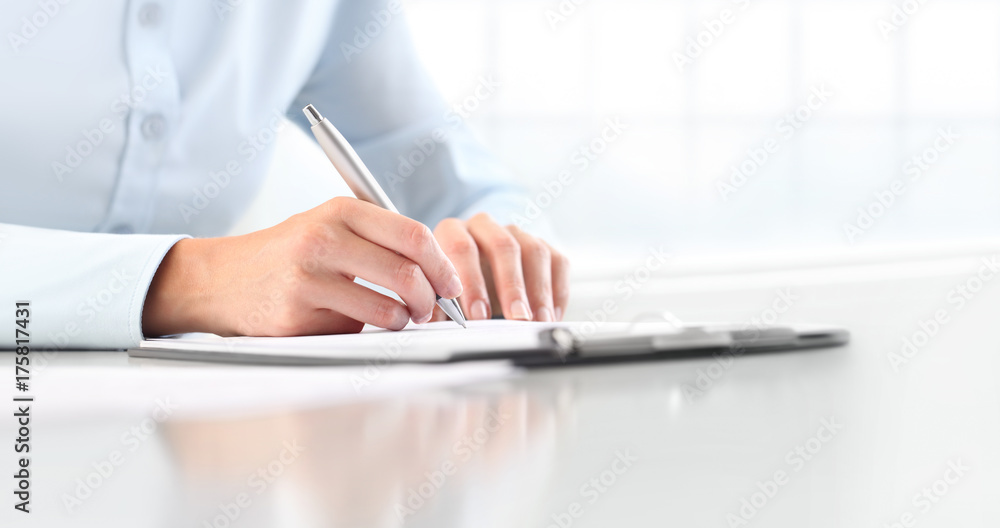 Woman's hands writing on sheet in a clipboard with a pen, isolated on ...