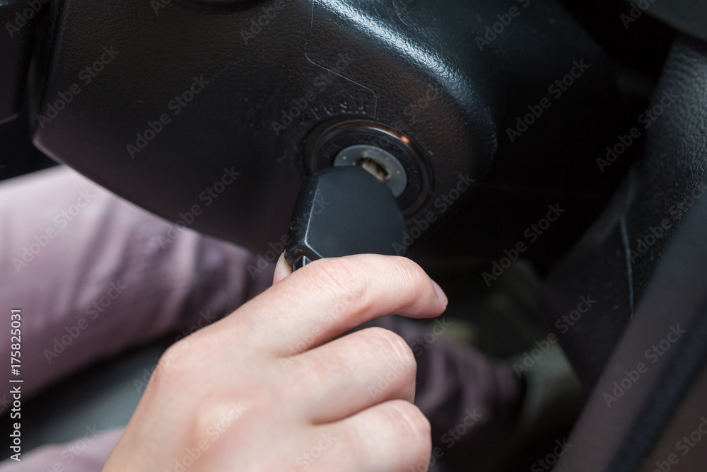 Closeup inside vehicle of hand holding key in ignition, start engine ...