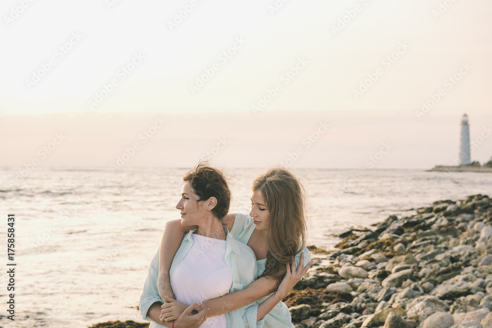 Close up portrait of mom and her teenage daughter hugging and smiling ...