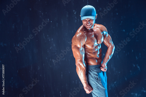Strong bodybuilder wearing baseball cap. Man with perfect abs ...
