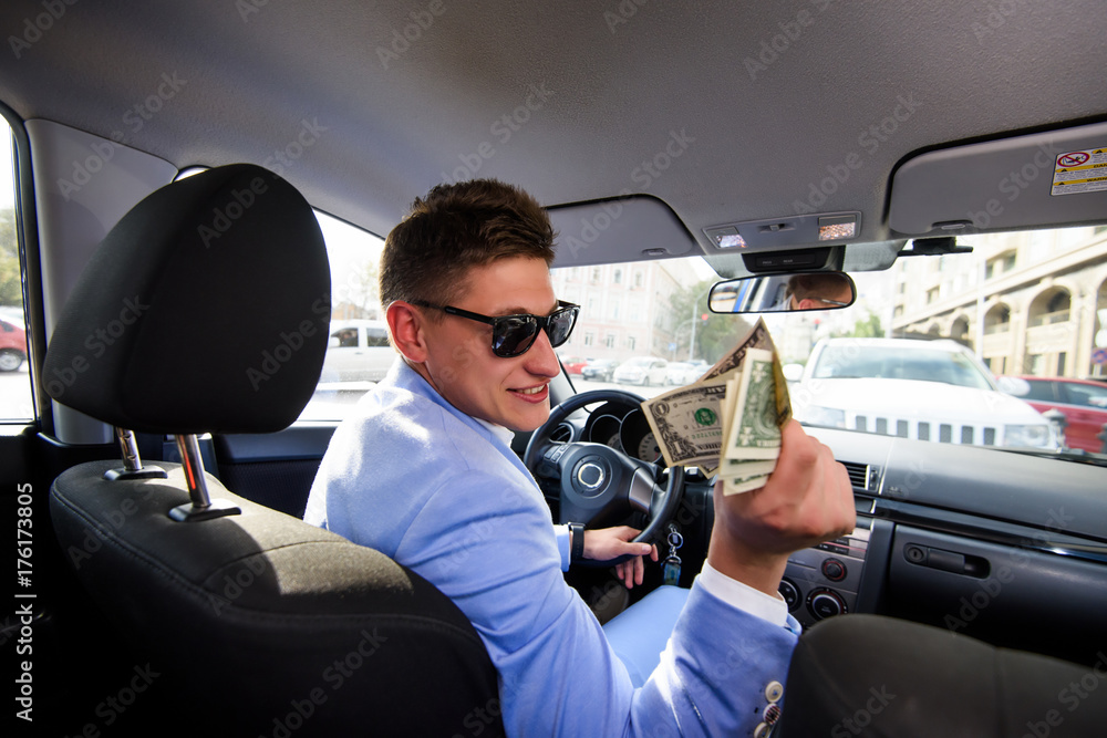Good looking taxi driver gives change to a client. The payment in the ...