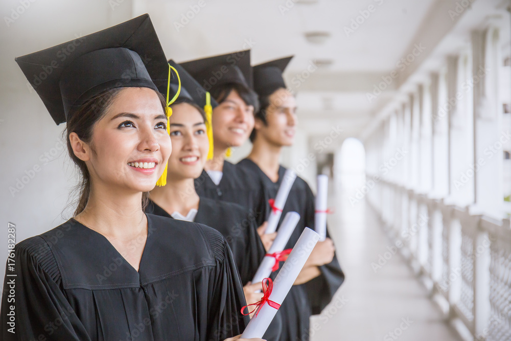 Portrait of young asian man and woman graduates standing in line in ...