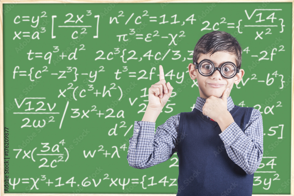 Education concept with funny smart school boy in front of a chalkboard ...