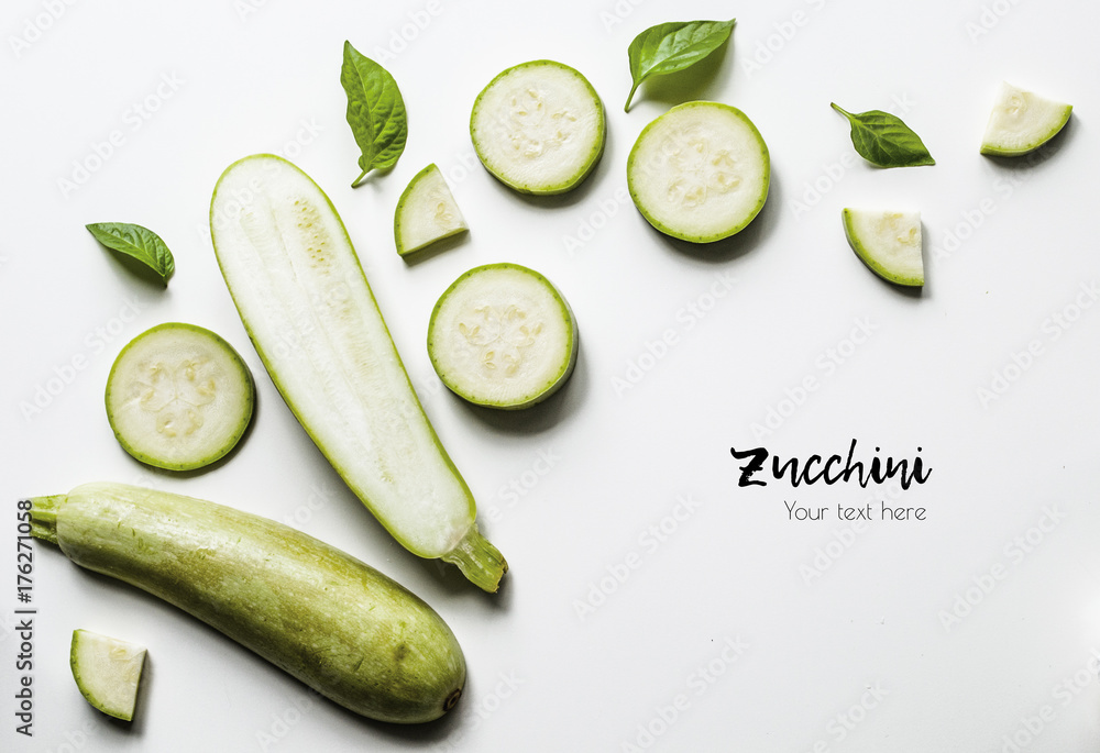 Creative layout of solid and sliced zucchini on white background with ...