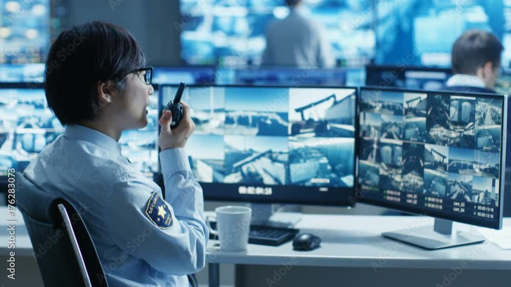 In the Security Control Room Officer Monitors Multiple Screens for ...