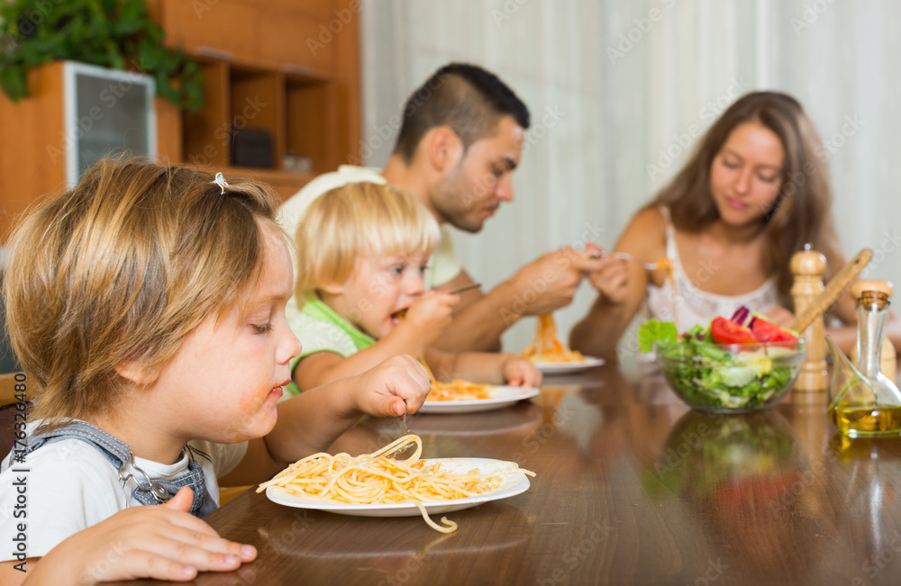 ordinary family of four eating spaghetti at Stock Photo | Adobe Stock