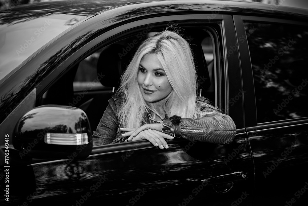 Pretty blonde hair woman on a road in automobile. Woman and car ...