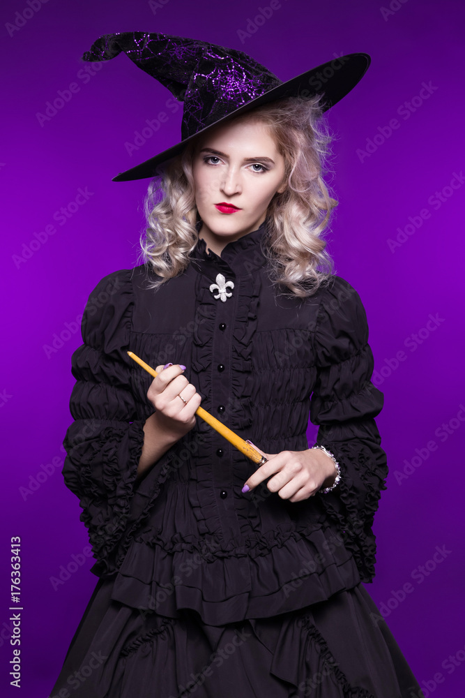 A strict, wicked teacher witch holds a pointer, a magic wand, on a ...