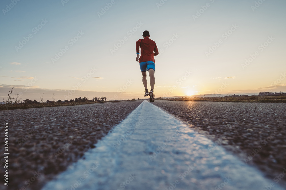 Uomo che corre su strada asfaltata Stock Photo | Adobe Stock