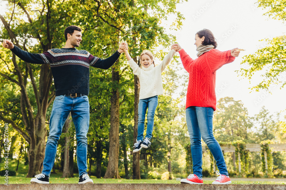 Foto de Excited small child being glad to have time with her parents ...