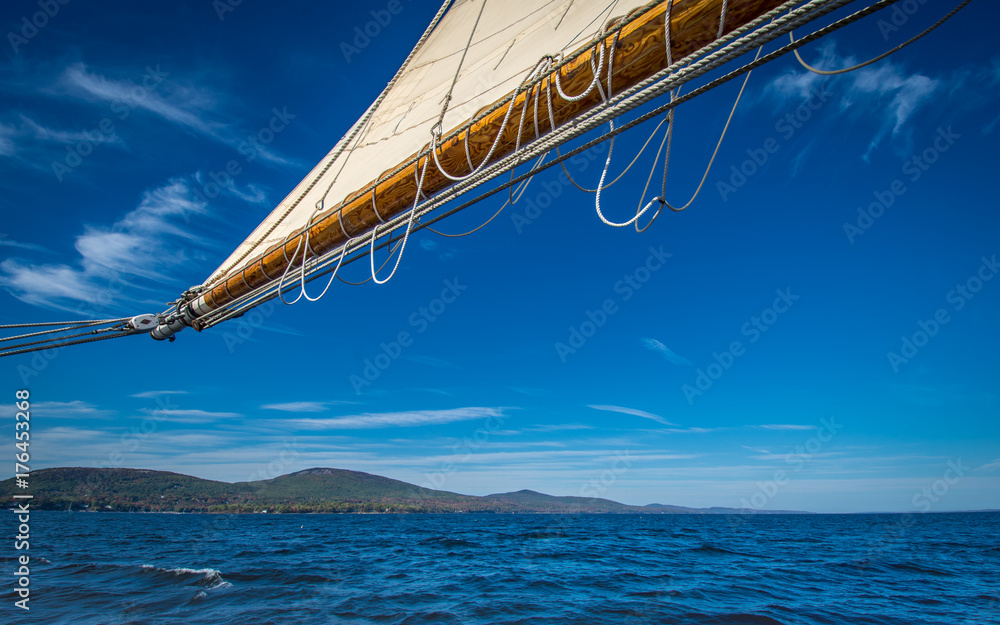 Sail and boom as the boat is sailing across the water Stock Photo ...