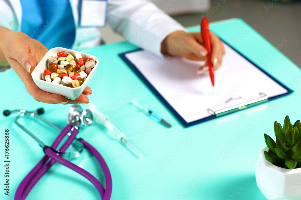 Female doctor hand hold pack of different tablet blisters at workplace ...