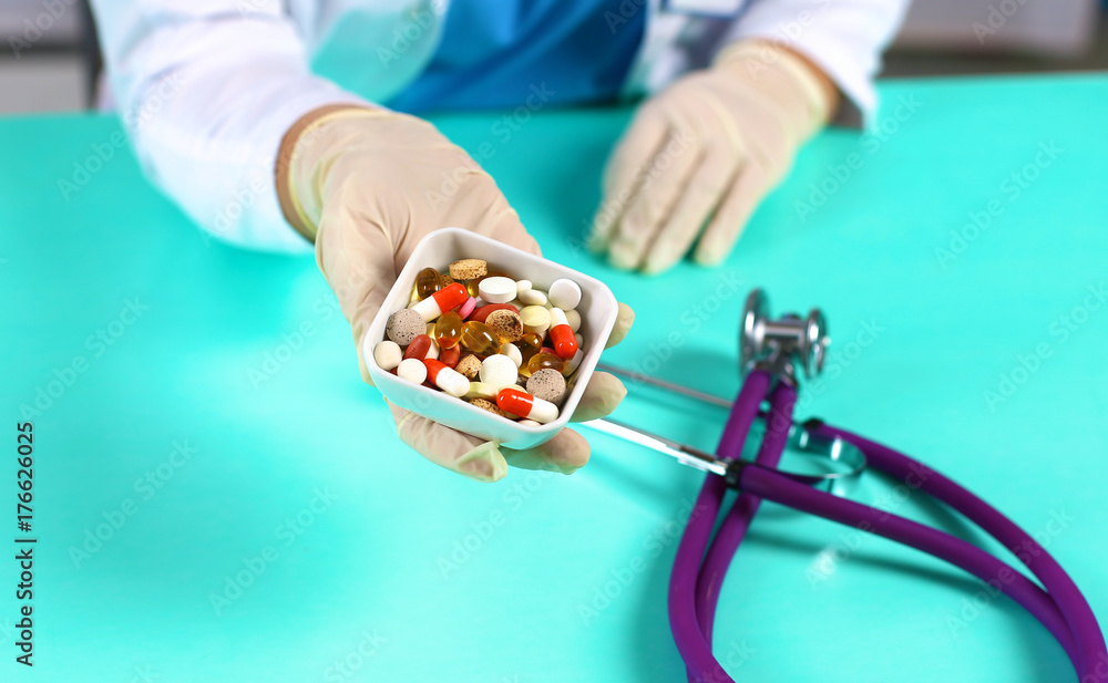 Female doctor hand hold pack of different tablet blisters at workplace ...