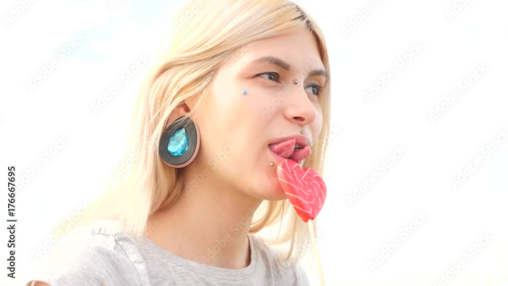 bodymification. a girl with a split tongue licks lollipop. 4k, slow ...
