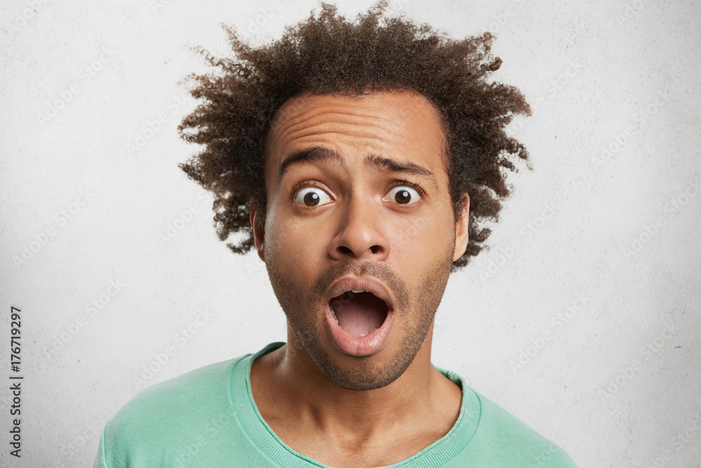 Headshot of scared horrified timorous man looks with bugged eyes as ...